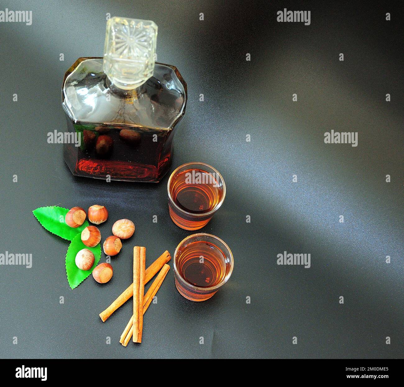 Nut liqueur with cinnamon and mint, strong homemade alcohol on a black ...