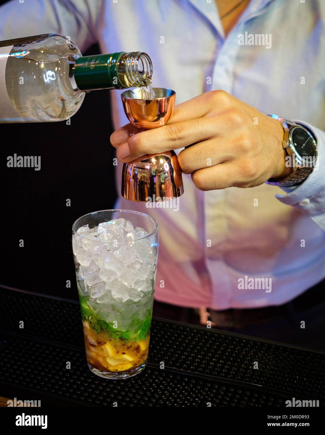 preparation of a cocktail based on lemon, pisco liqueur, fresh mint and ...