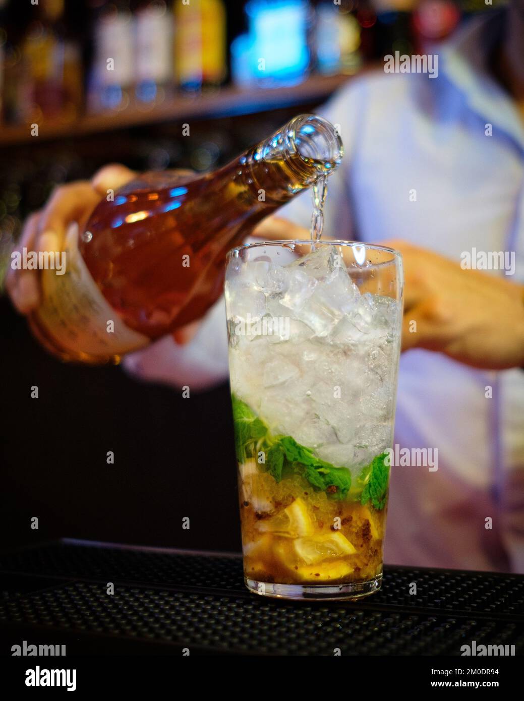 preparation of a cocktail based on lemon, pisco liqueur, fresh mint and ...