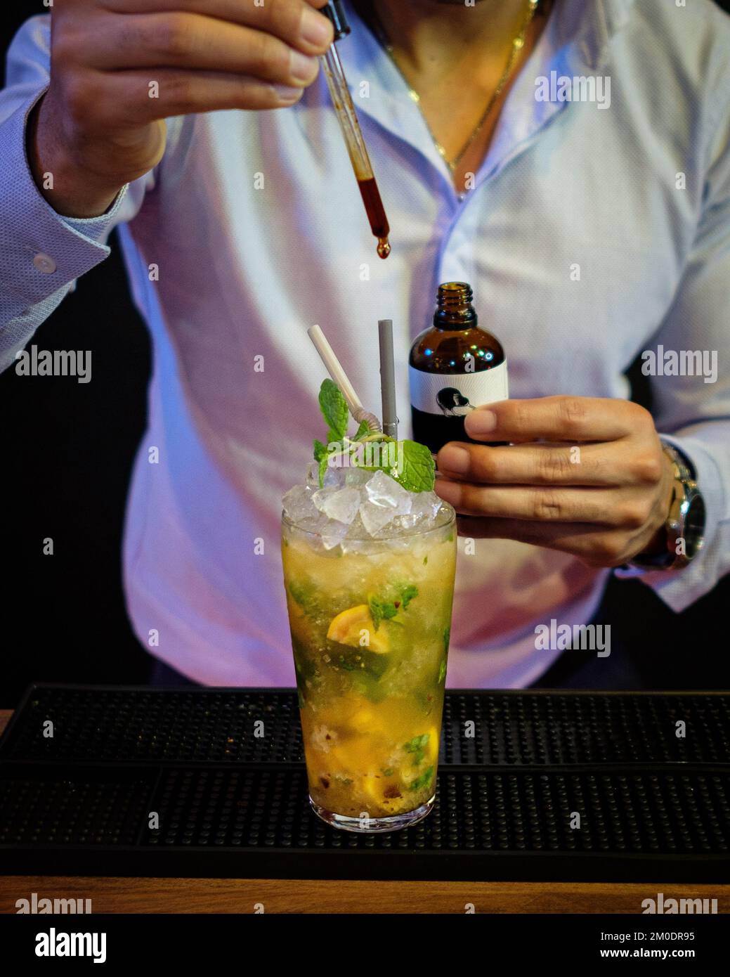 preparation of a cocktail based on lemon, pisco liqueur, fresh mint and ...