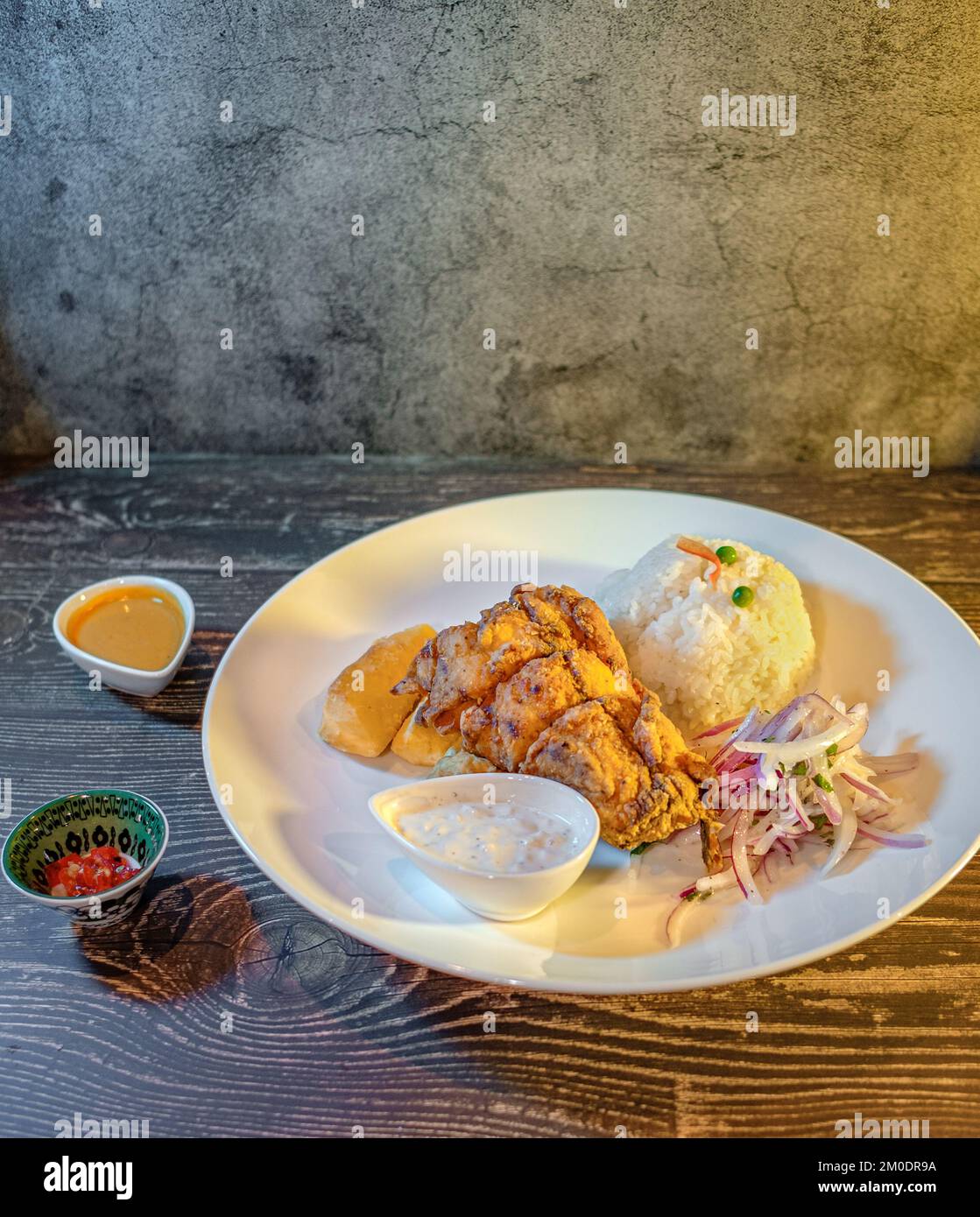 Fried fish filet with white rice, potatoes and salad Stock Photo - Alamy