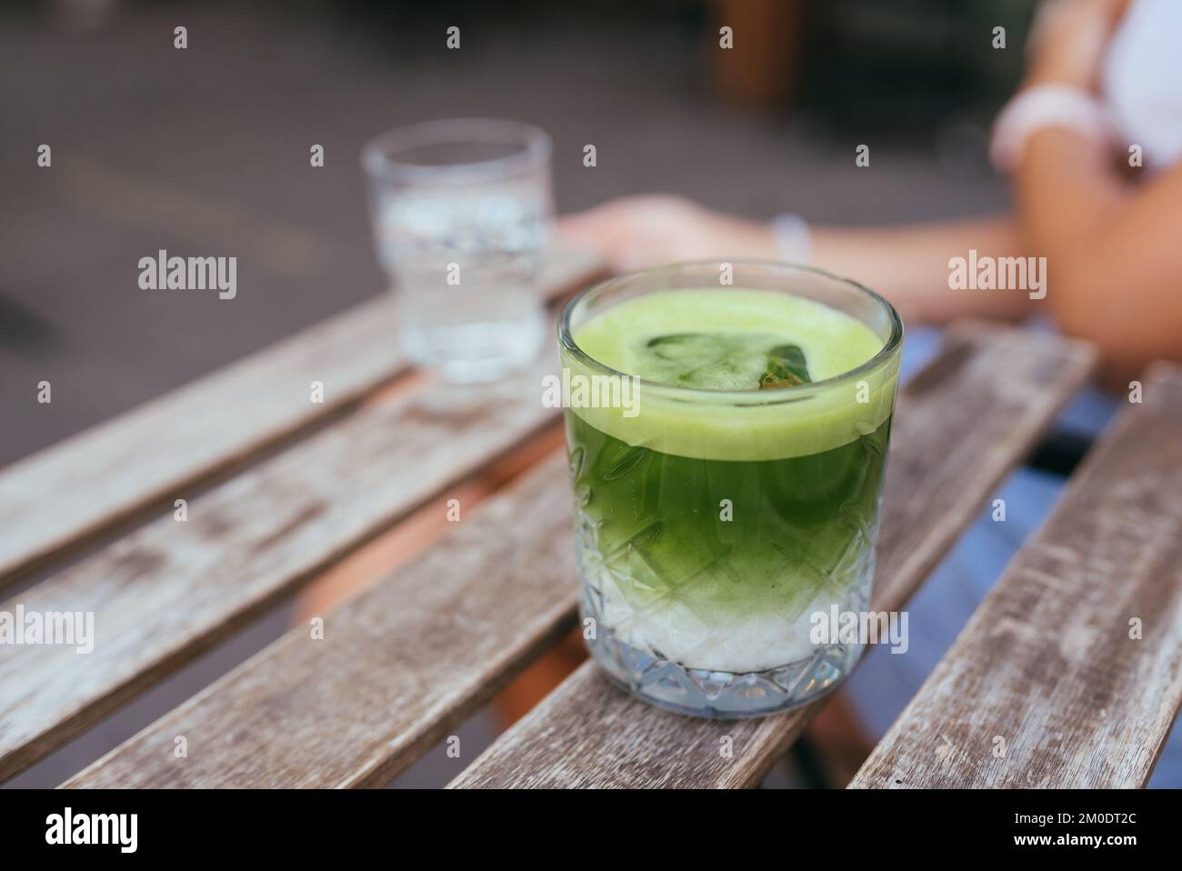 Iced green matcha latte tea on wooden table Stock Photo - Alamy