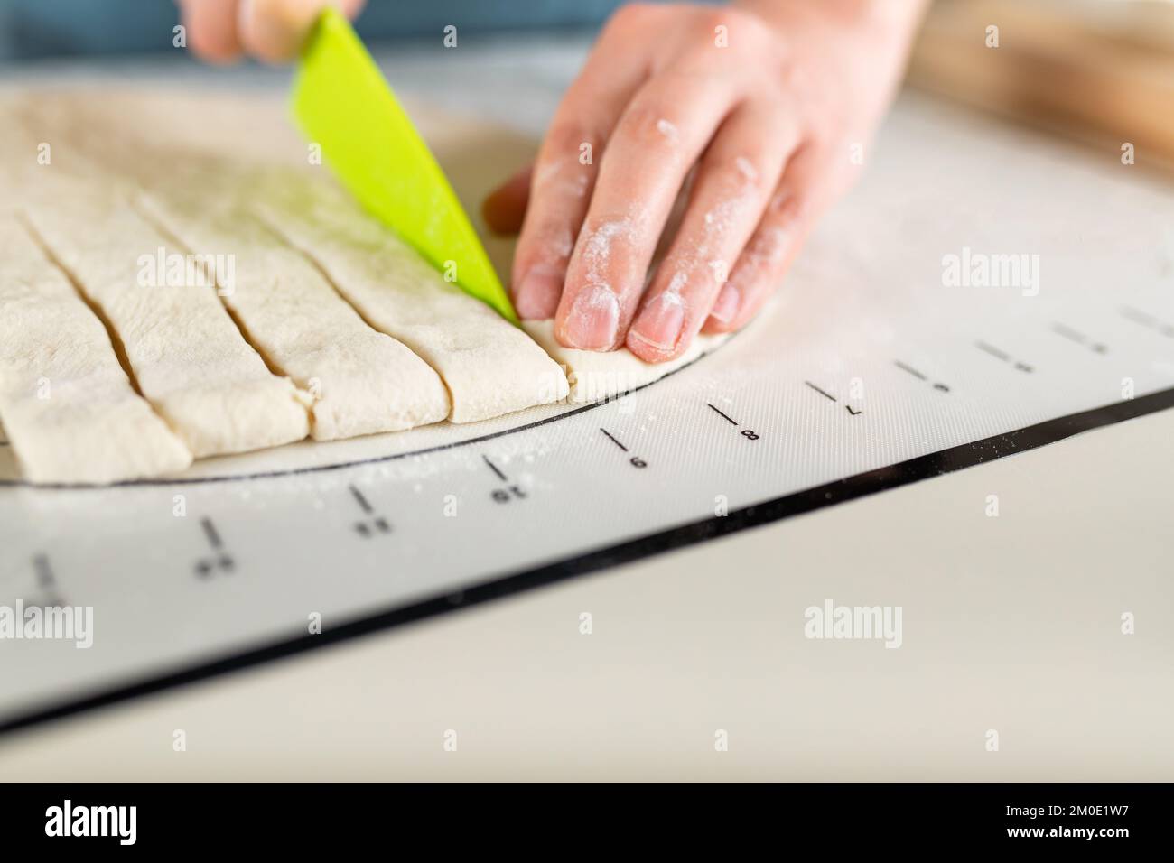 Close-up of cutting the rolled dough into equal parts according to the ...
