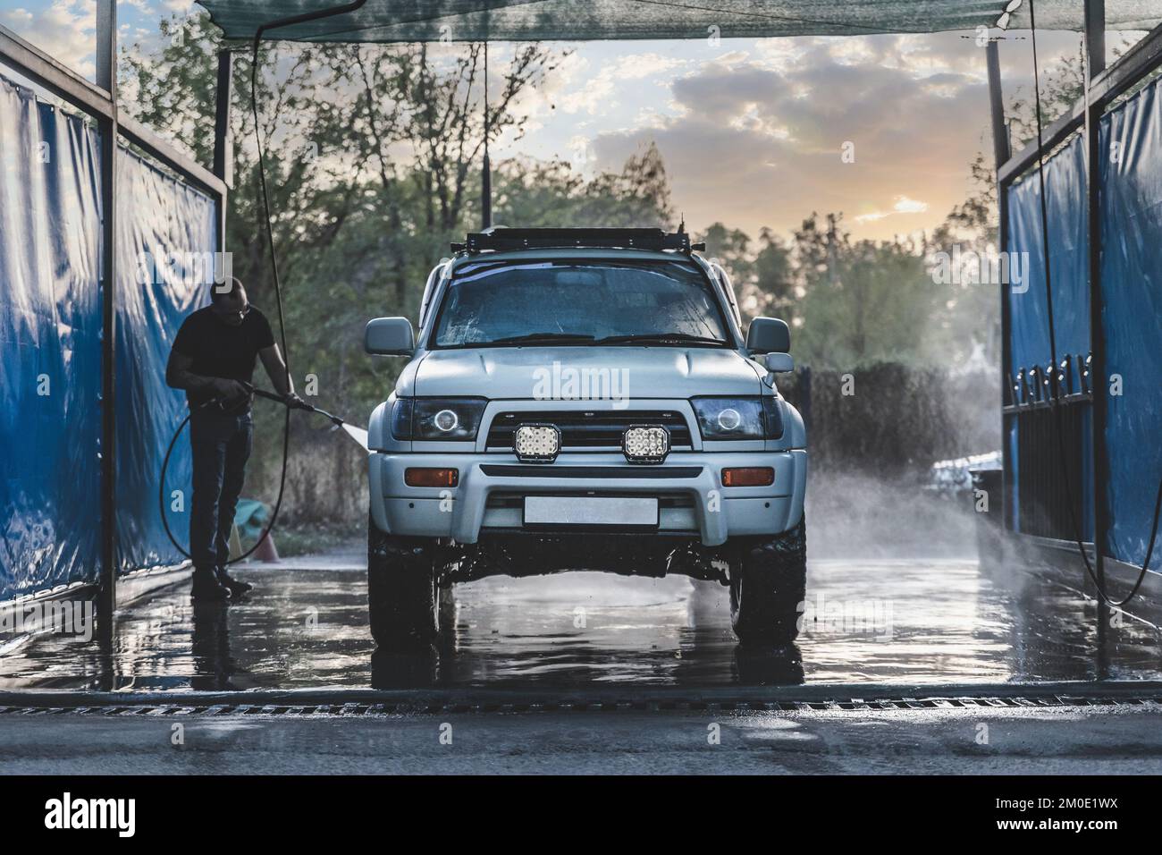Man on Self-service washes his white suv 4x4 car Stock Photo - Alamy