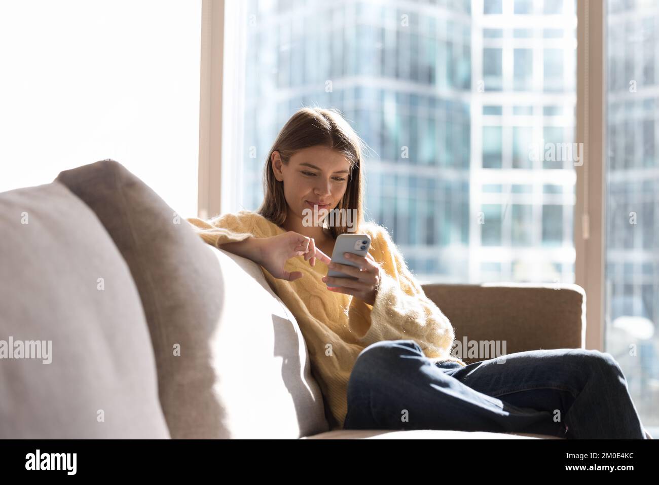 Happy thoughtful millennial gen Z girl using mobile phone Stock Photo ...