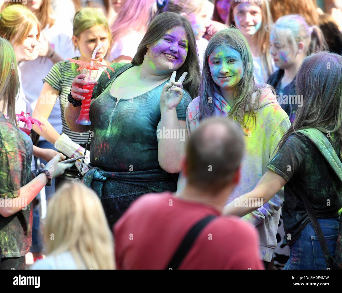 Two young girls sprinkled with colored powder pose for a photo during ...