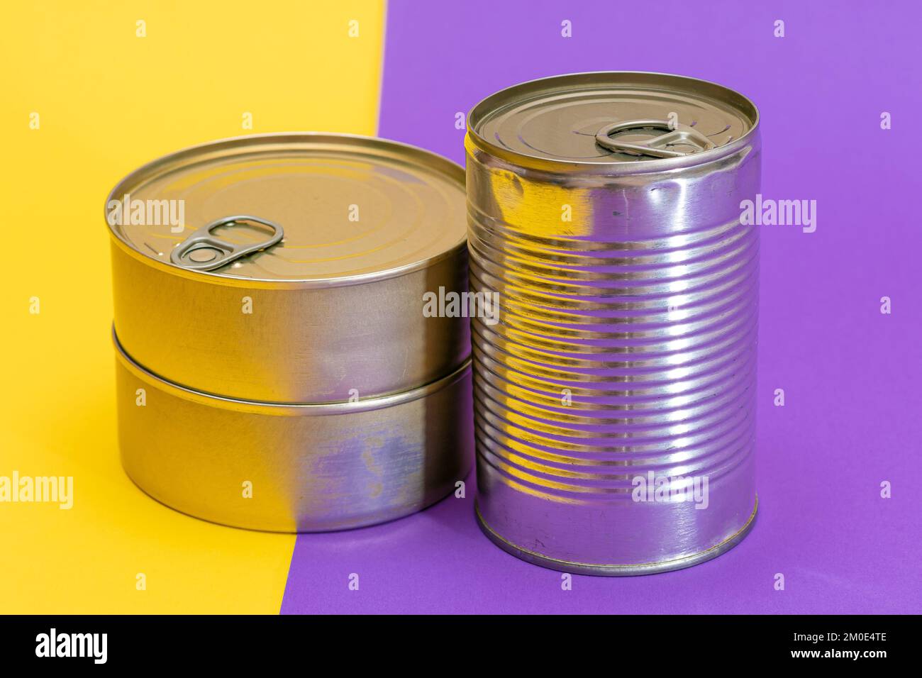 A Group of Stacked Tin Cans with Blank Edges on Split Yellow and Violet ...