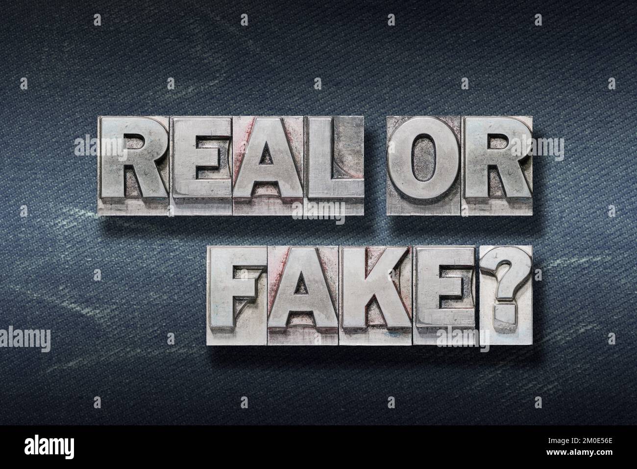 real or fake question made from metallic letterpress on dark jeans ...