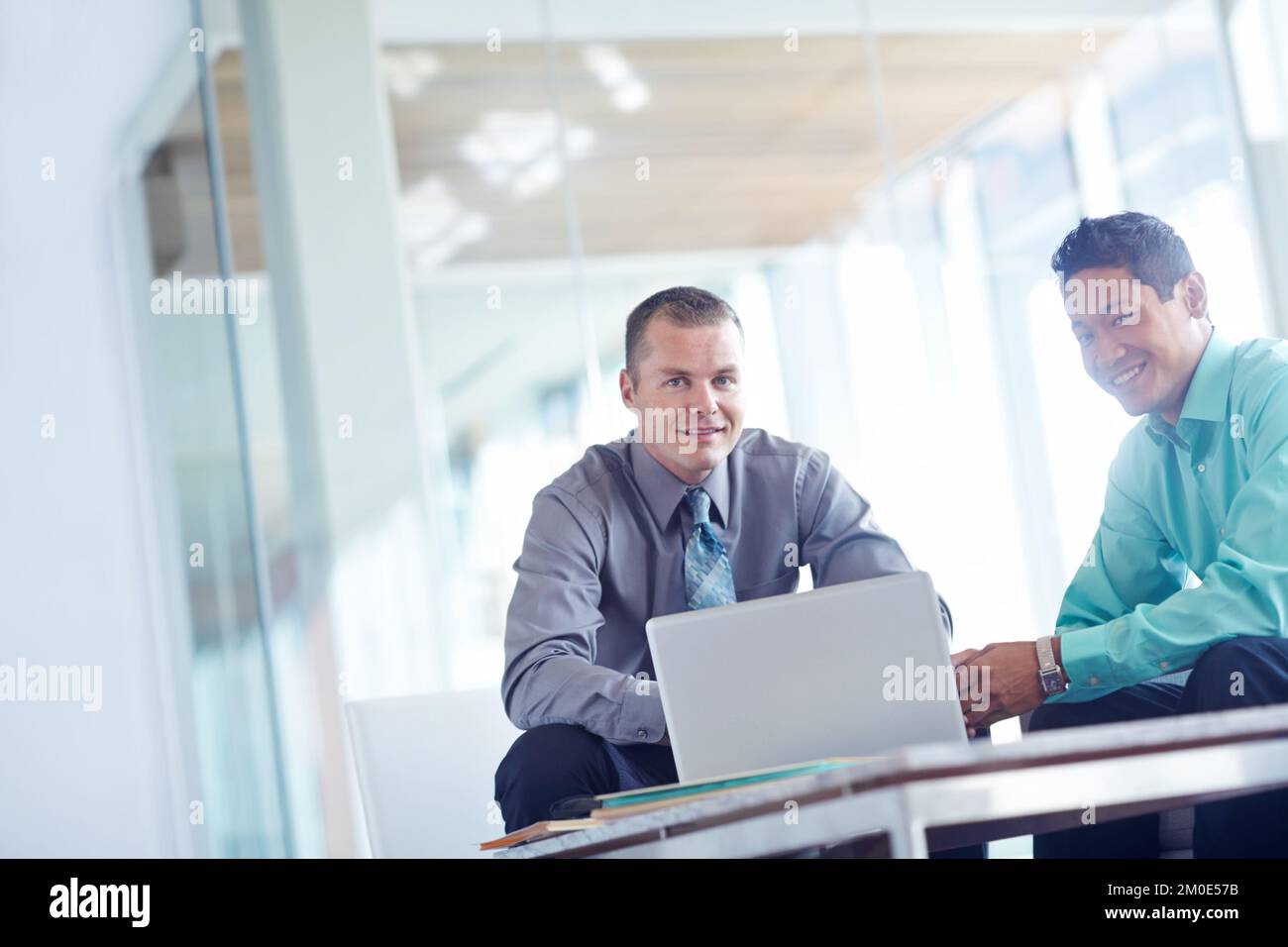 Working together ensures them success. Two handsome young businessmen ...