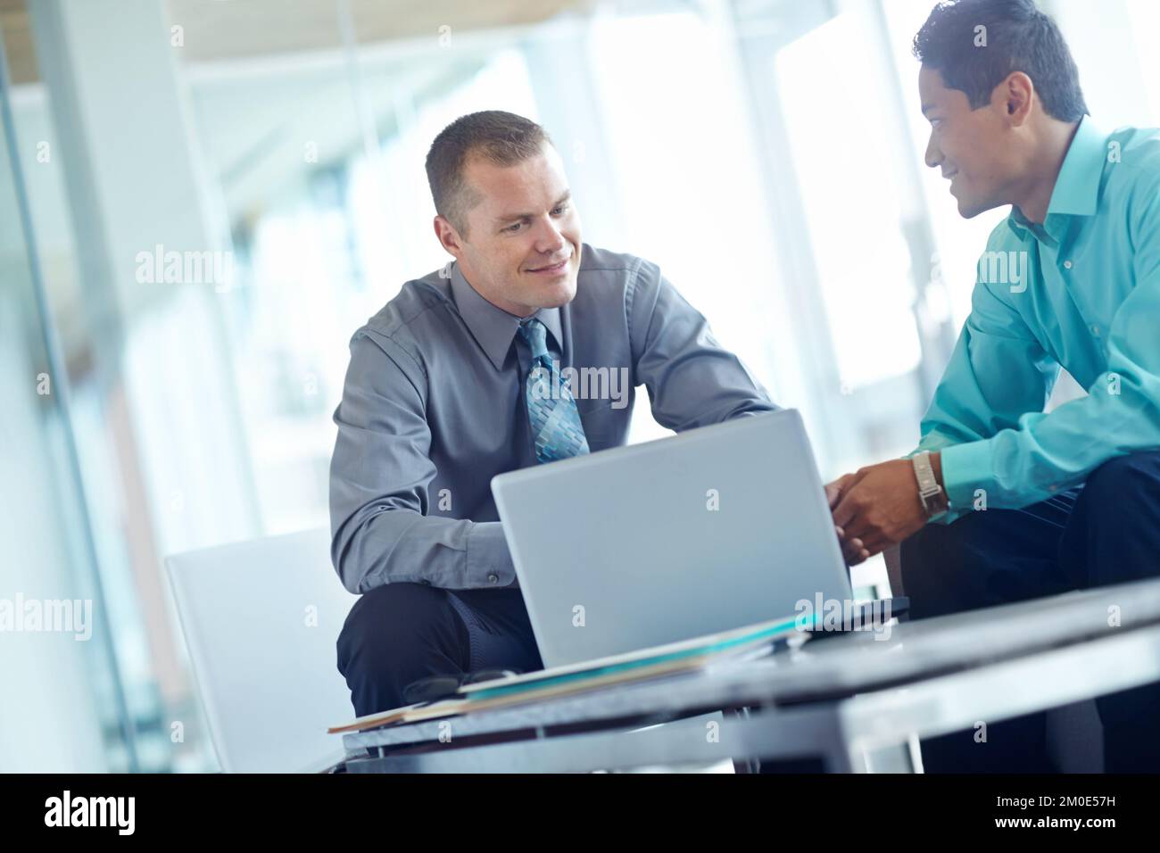 Working as a corporate team. Two handsome young businessmen working ...