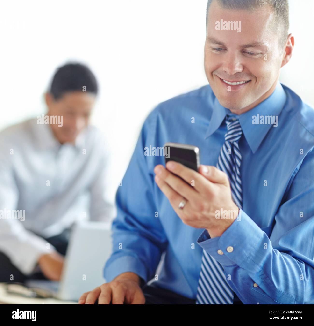 Checking his business texts. A smiling caucasian businessman using a ...