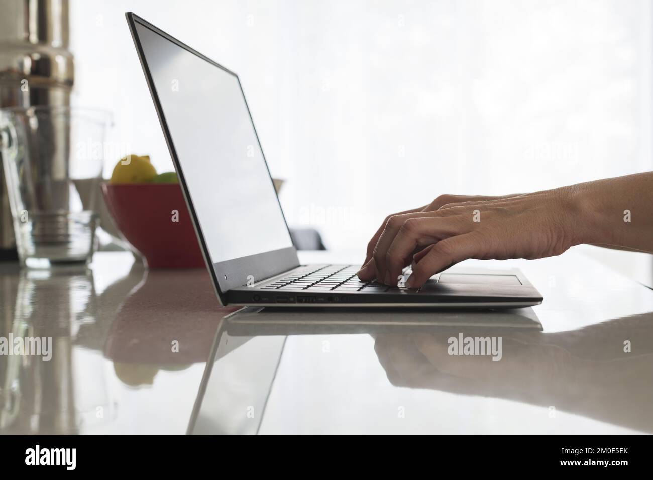 Close up of female hands typing on keyboard of modern laptop computer ...