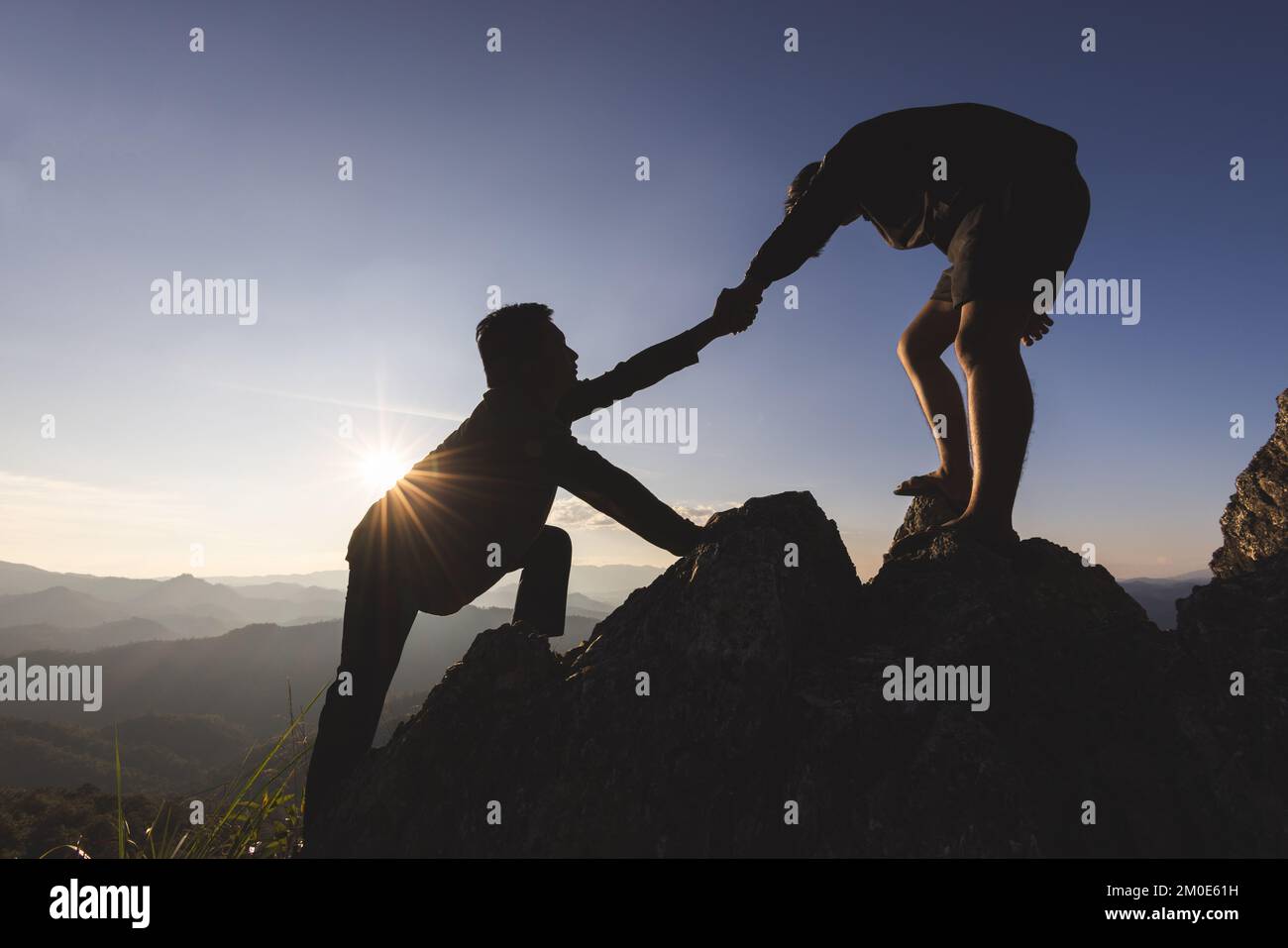 Silhouette of The men helping pull people up from high cliffs Stock ...