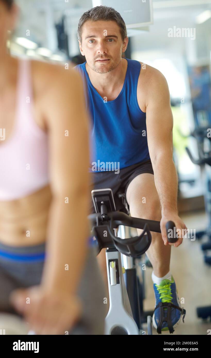 Showing the cycle whos boss. A man and woman exercising in spinning ...