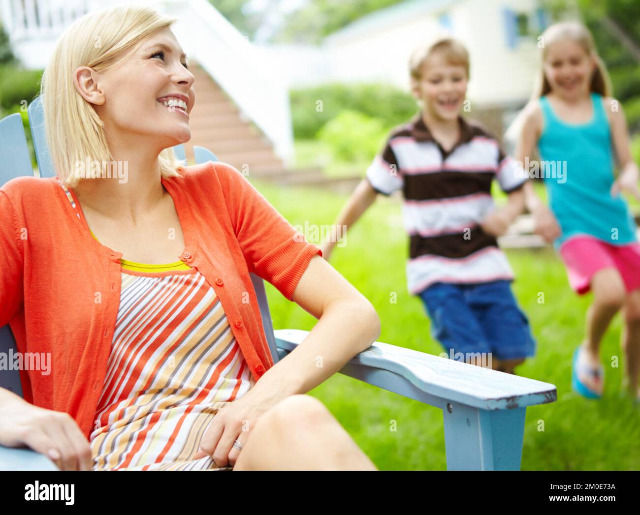 Children are such a treasure. Happy young mother sitting outdoors as ...
