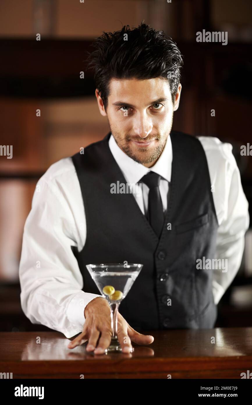 Here, try this. Portrait of a handsome young bartender mixing a ...