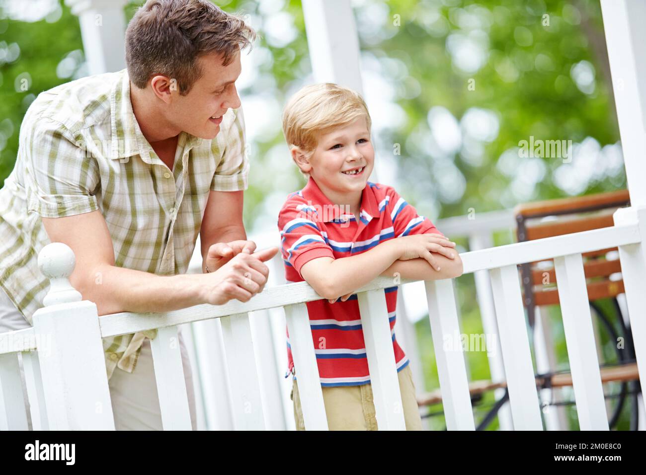 Bonding on the porch. A young boy and his father sharing some quality ...