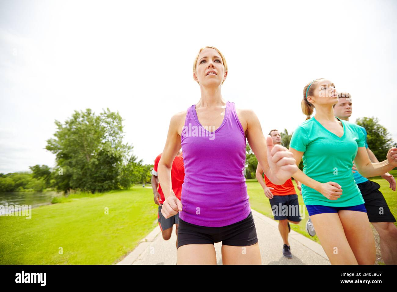 Training outdoors. Front view of a group of runners on an outdoor track ...