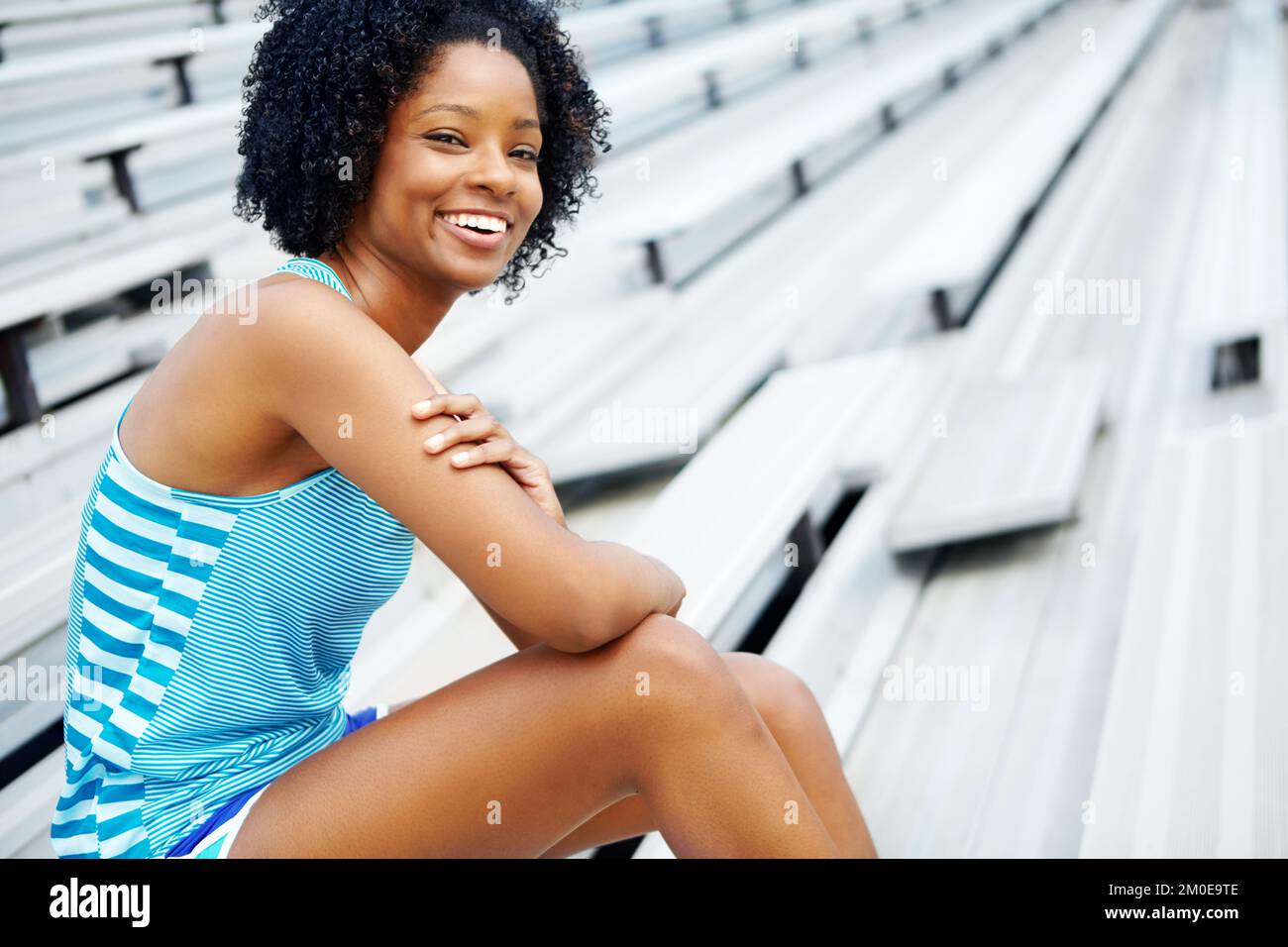 Taking a break from her workout. Side view of a female athlete sitting ...