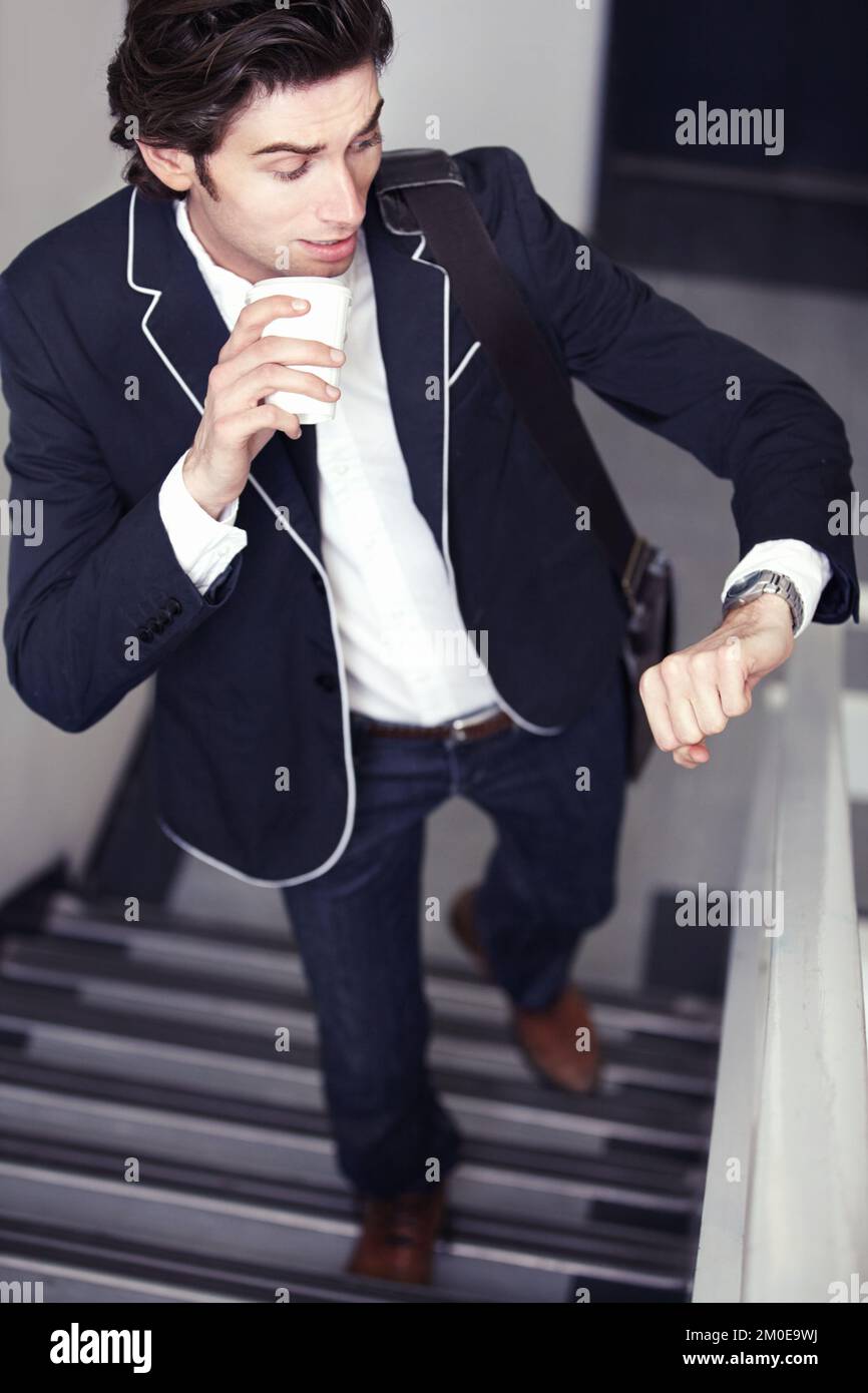 Im late. A young man realising hes late while walking up the stairs ...