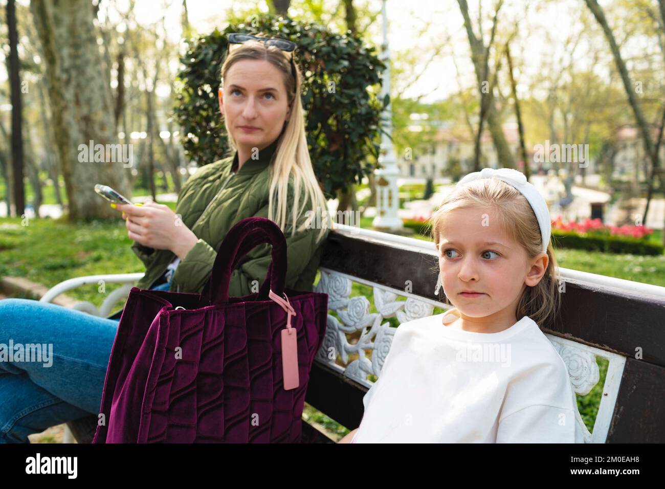 Young mother and small daughter sitting on the bench in park Stock ...