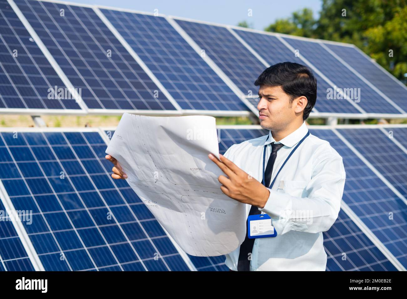 Young engineer inspecting solar panel plan at power plant - concept of ...