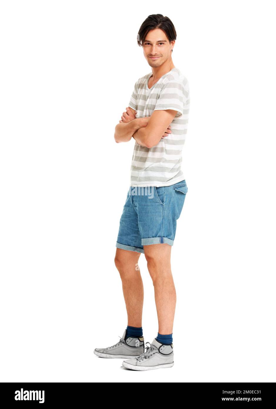 Simply unique. Young trendy man smiling at the camera with arms crossed ...