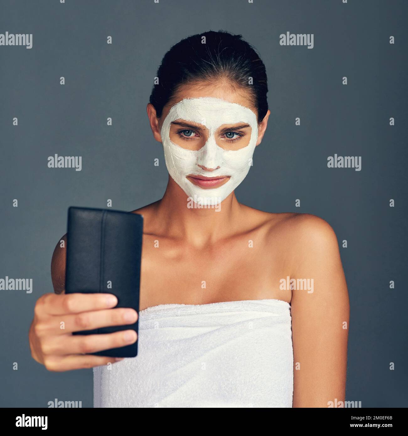 Sharing her beauty secrets. Studio sho of a young woman taking a selfie ...