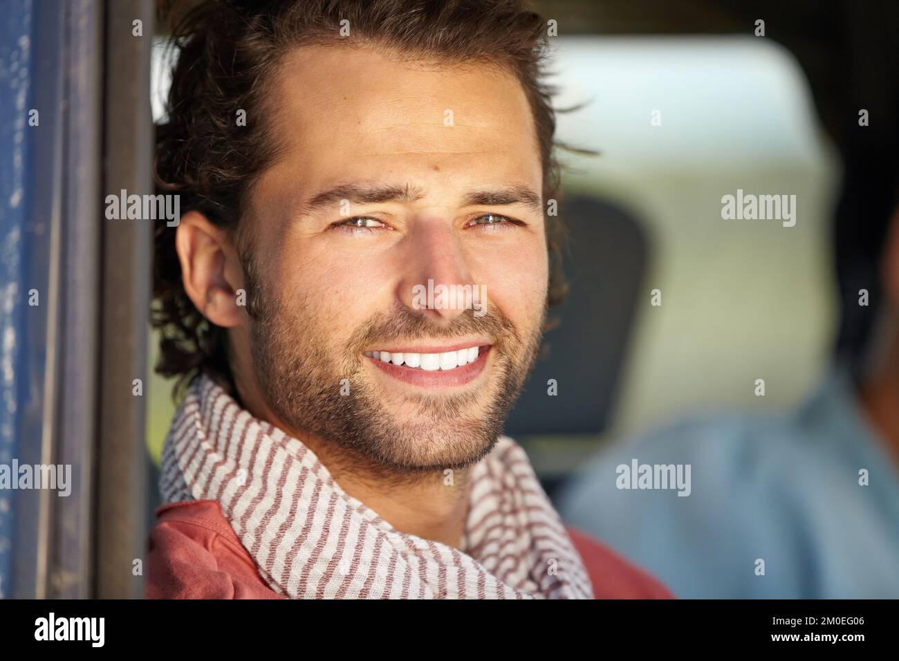 Ready for the road. A young man smiling and laughing while on a road ...