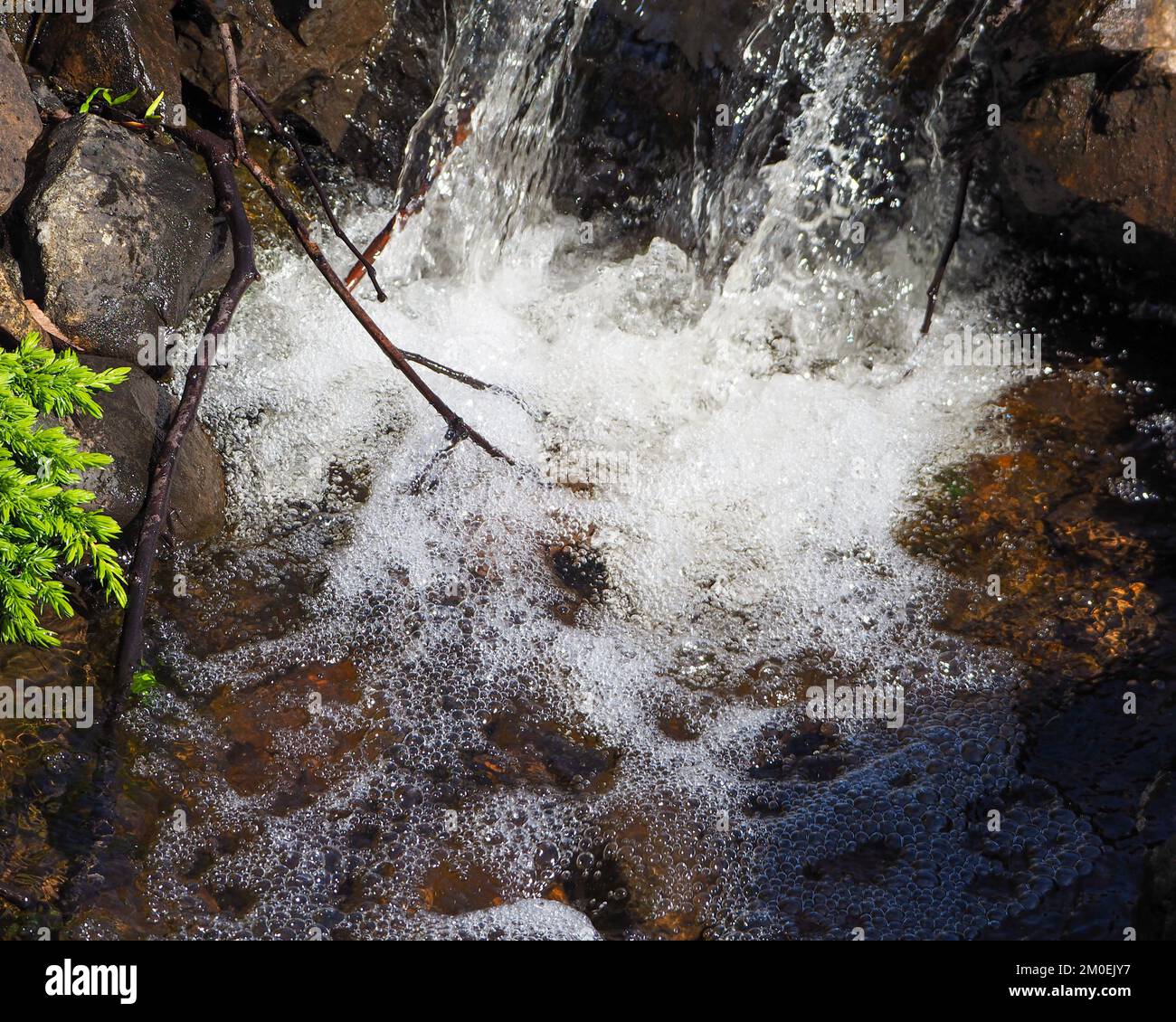 Water, bubbling and frothing its way down a man made waterfall into a ...