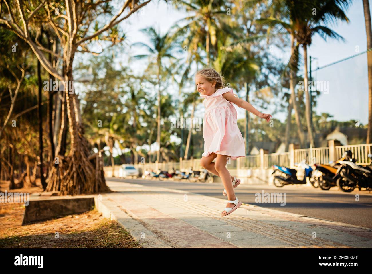 Happy little caucasian girl five years old walking on the city road on ...