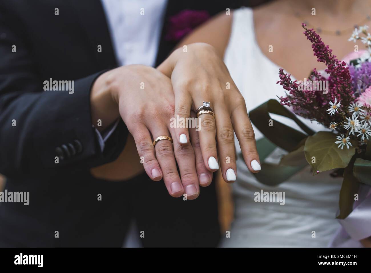 Bride and groom showing wedding rings on their fingers close up. High ...