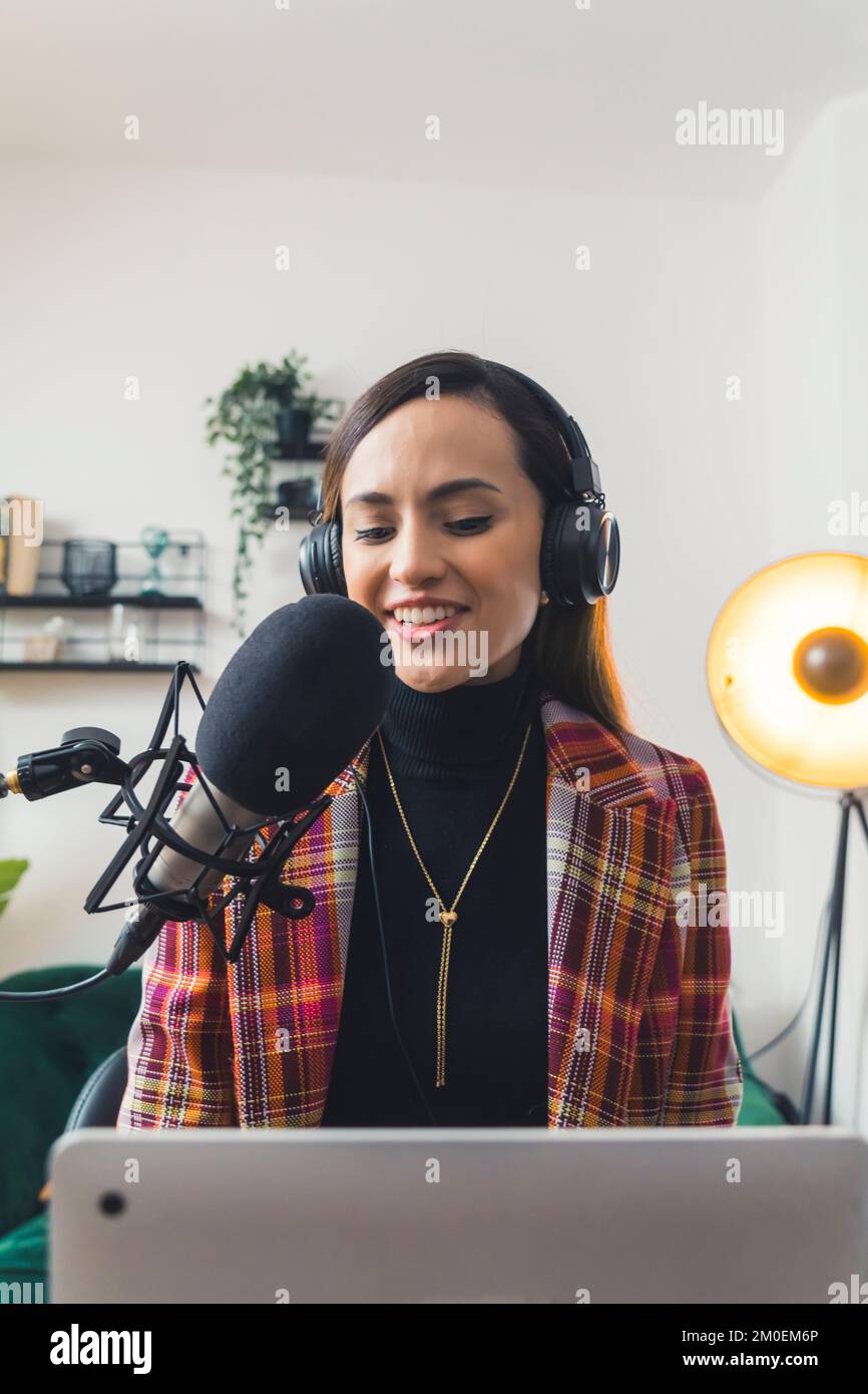 vertical shot of a smiling girl with headphones talking to her guest ...