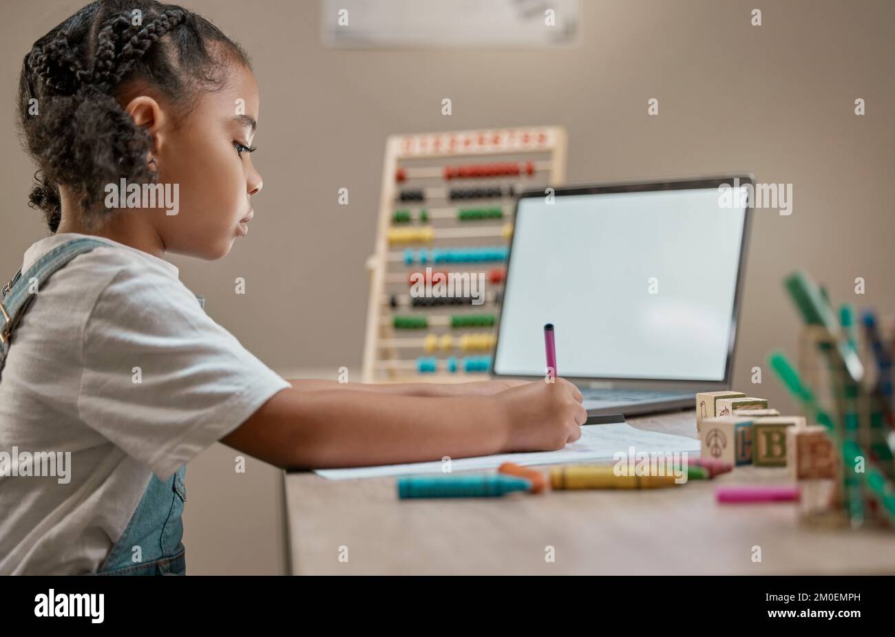 Girl writing, education toys and laptop in house with crayons, paper ...