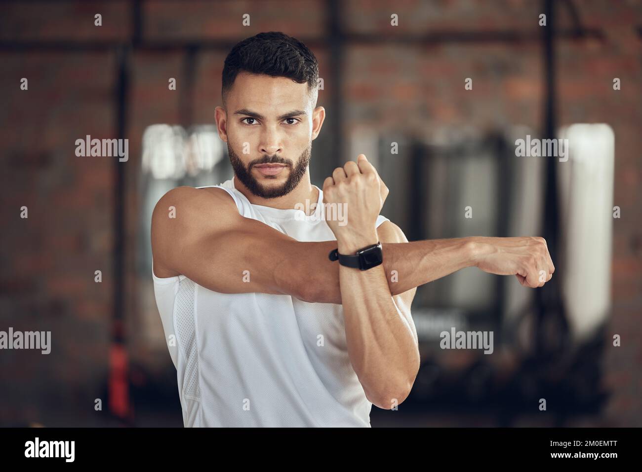 Portrait of focused athlete stretching in the gym. Young bodybuilder ...