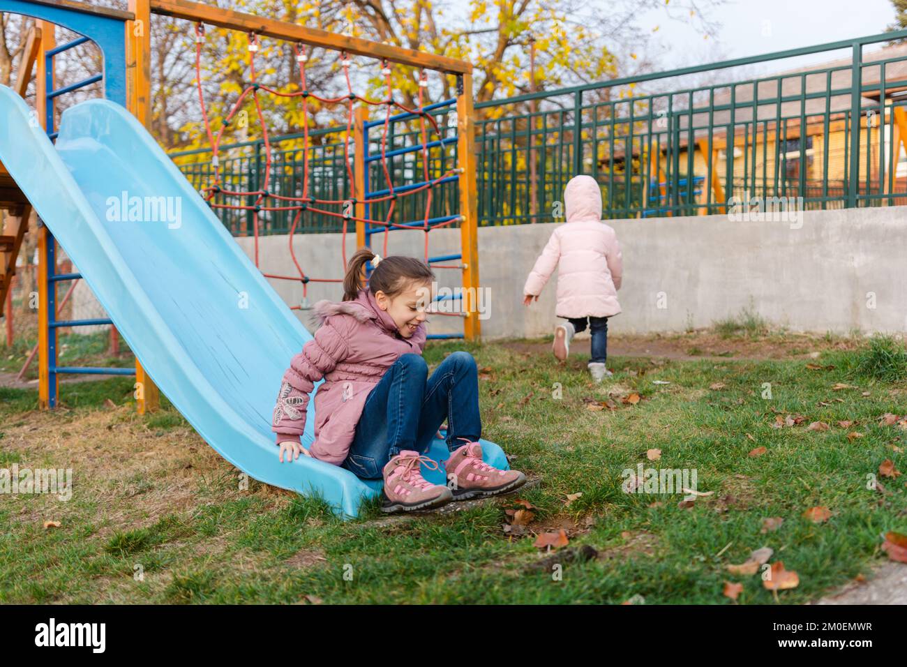 Children at the playground having fun while sliding Stock Photo - Alamy