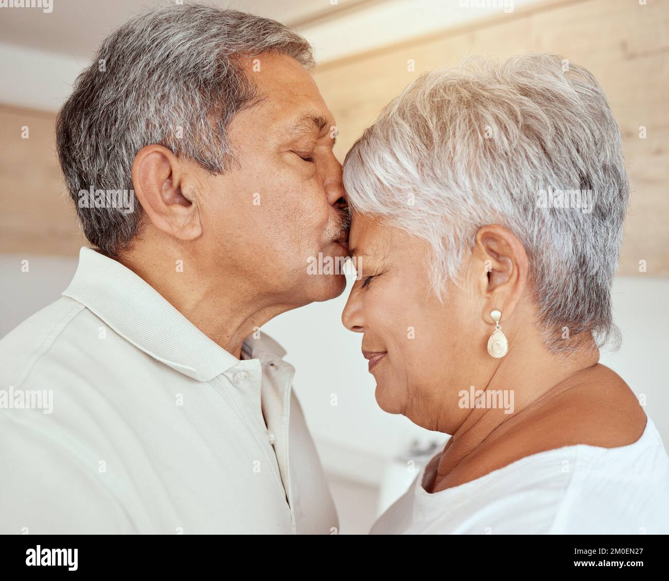 Closeup Of Mixed Race Senior Man Kissing Wifes Forehead In The Morning