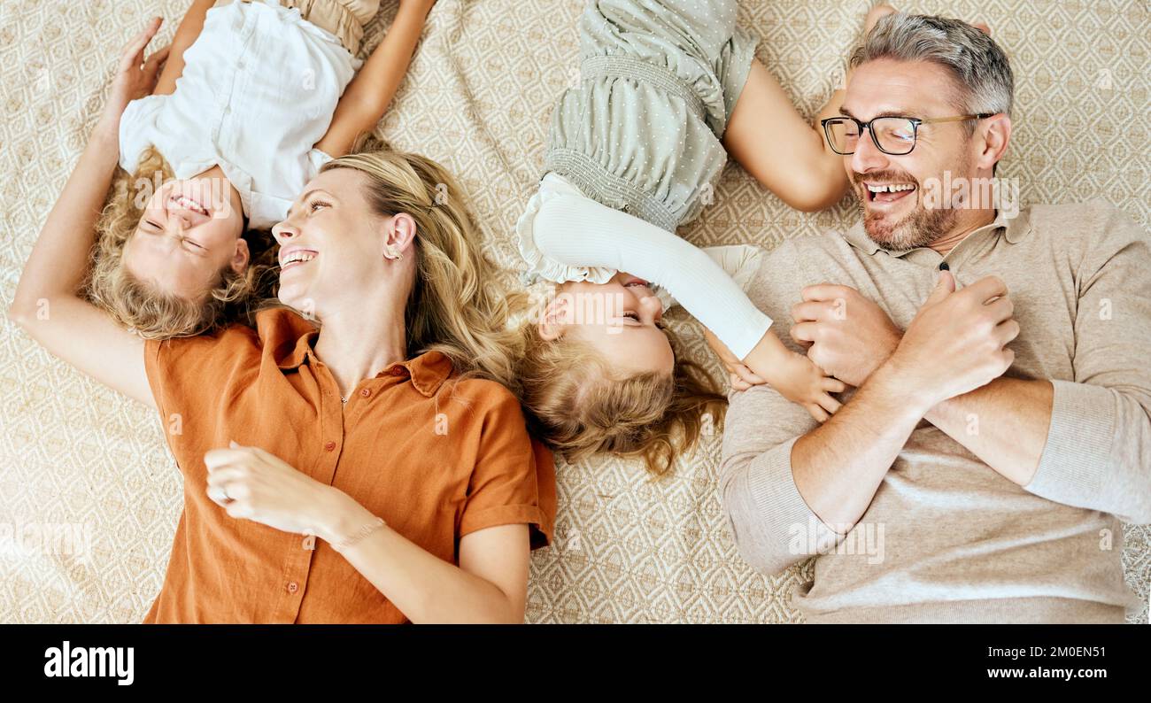 A happy Caucasian family of four lying in the living room at home ...