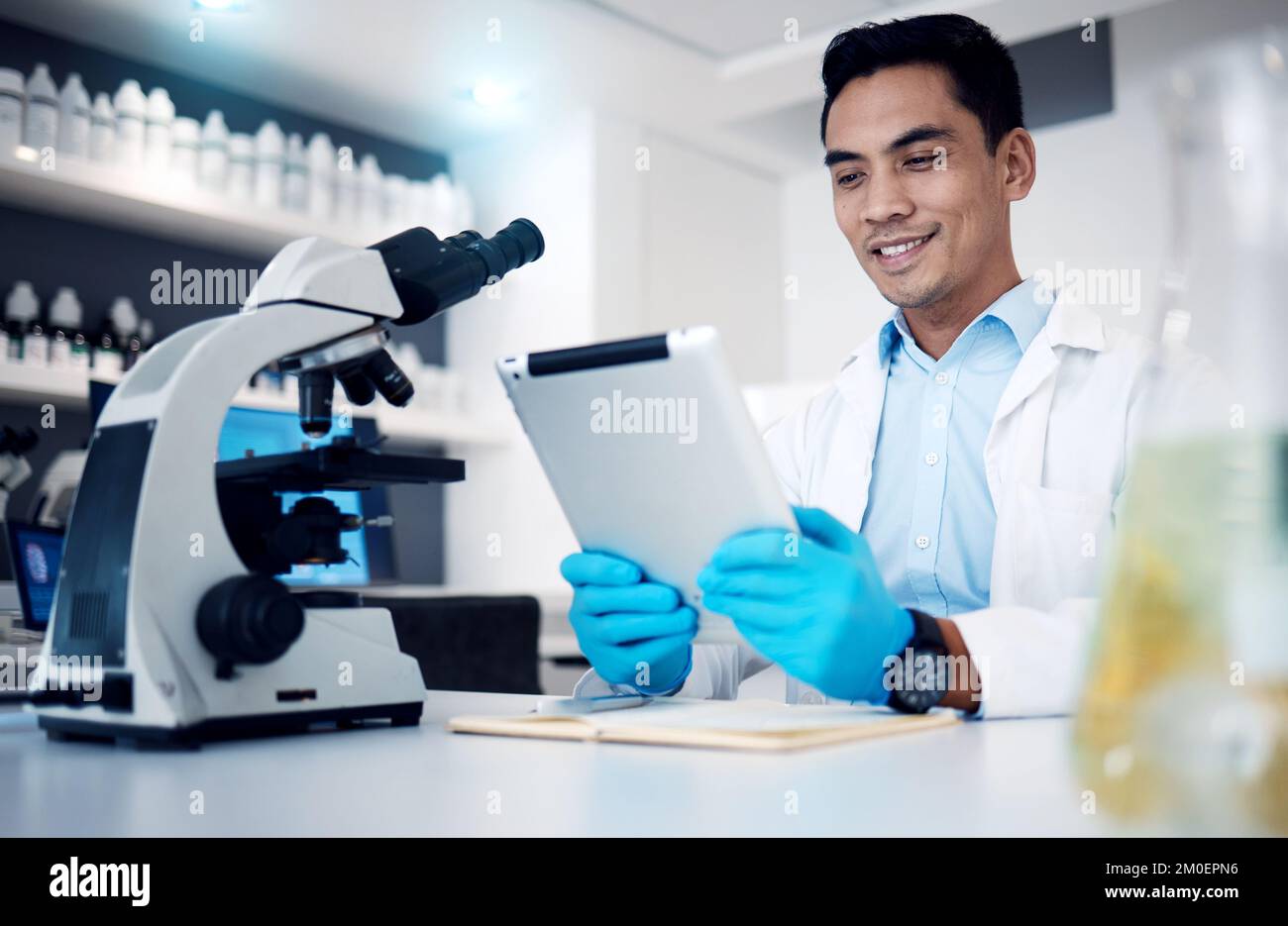 Science, tablet and microscope with a man at work in a laboratory for ...