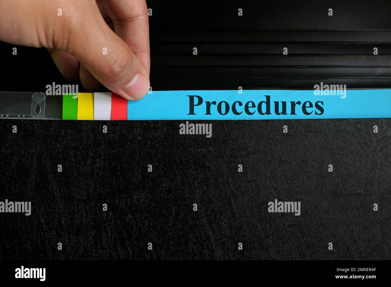 Hand picking procedures file record in black binder folder. Work ...