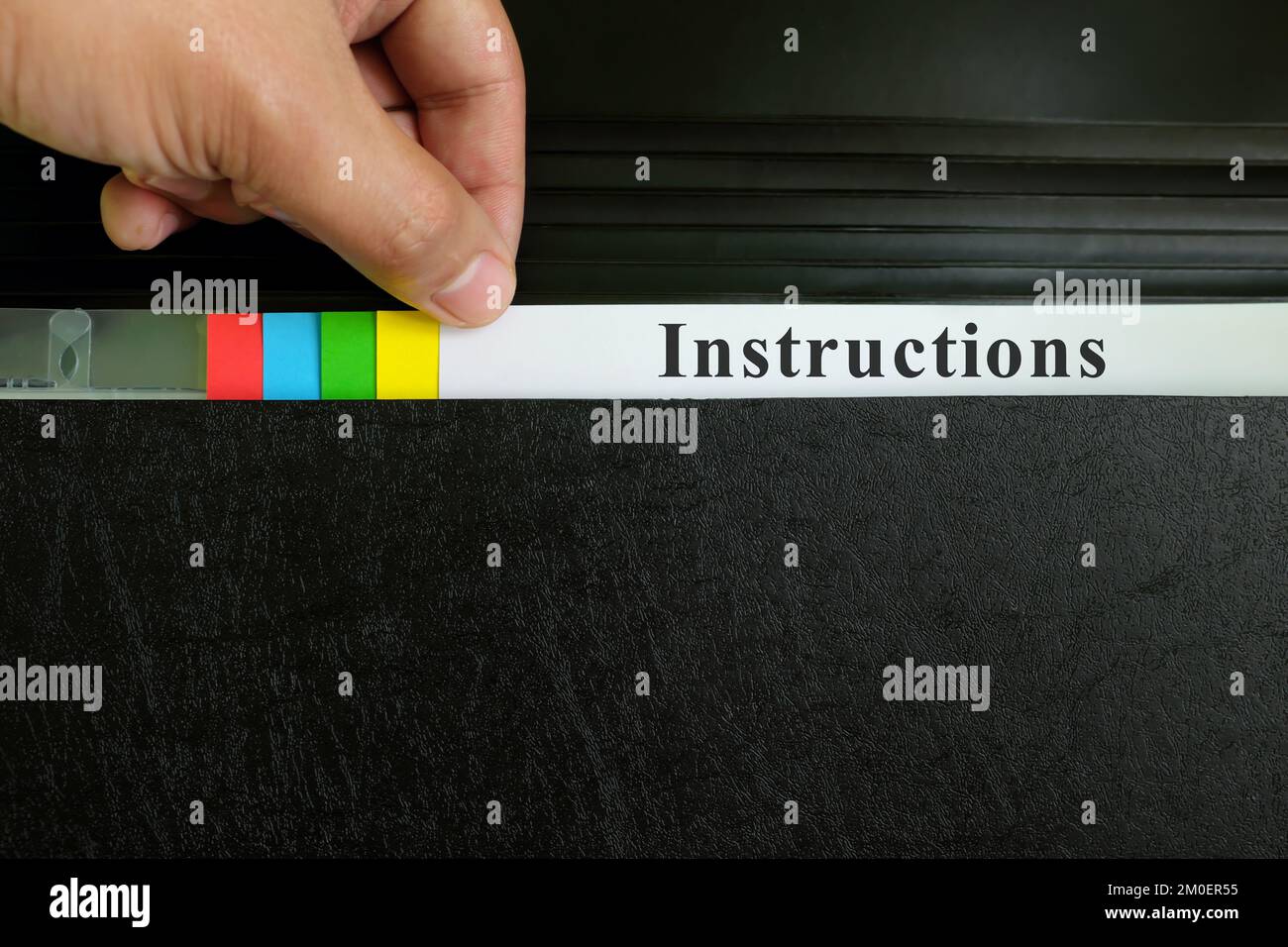 Hand picking instructions file record in black binder folder. Work ...