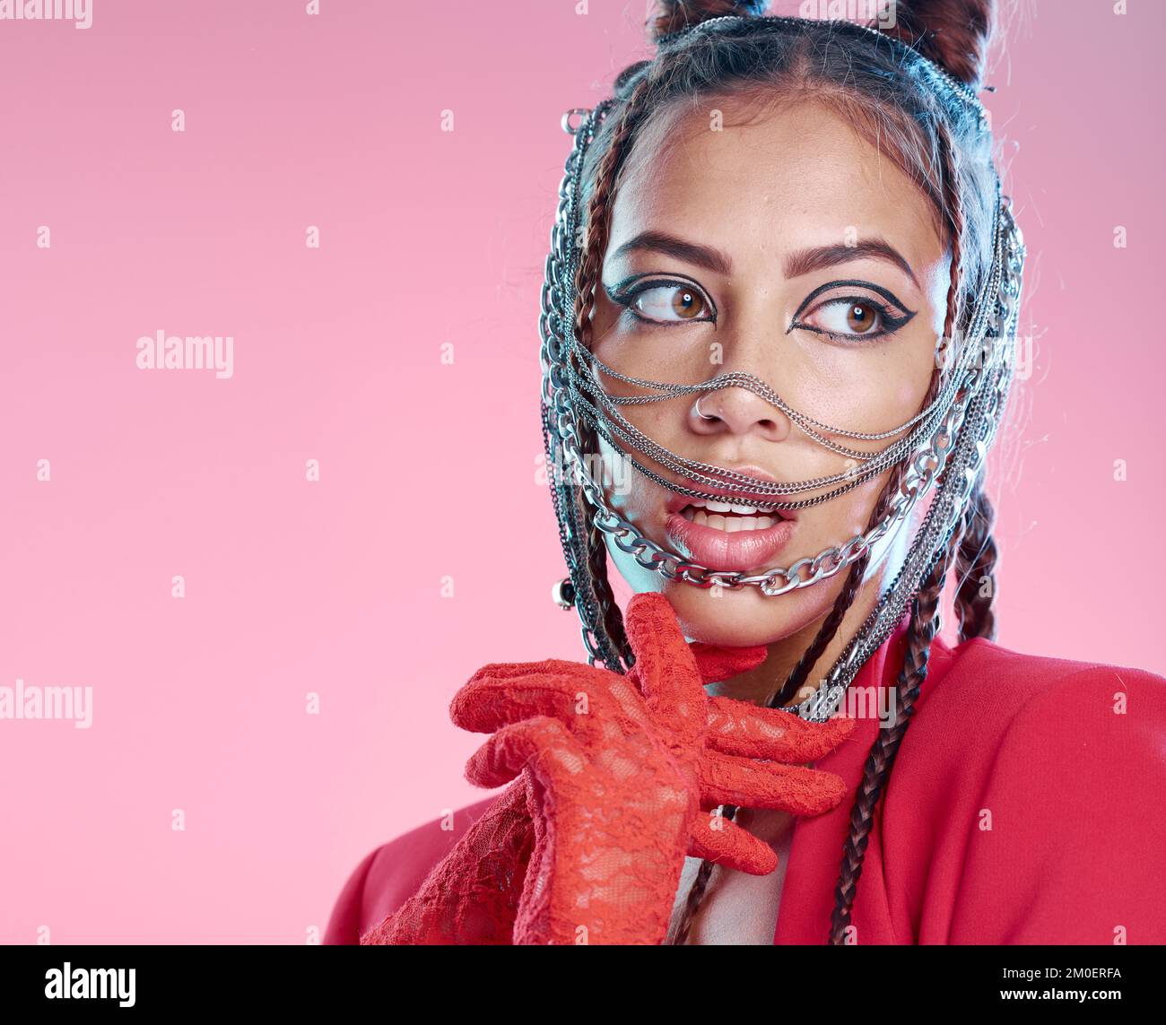 Punk, goth and stylish woman with face chains posing on a pink studio ...