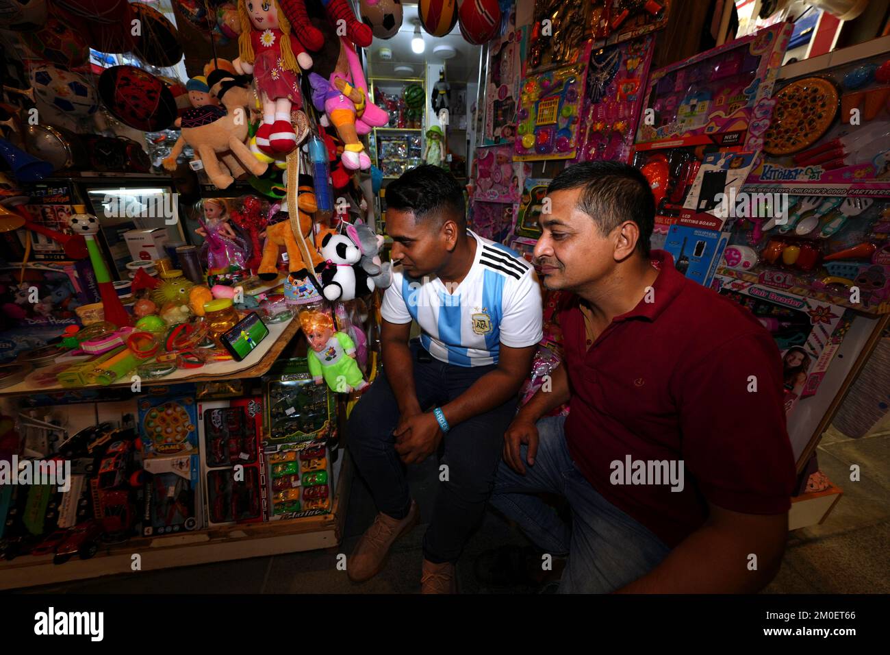 A shop keeper watches the Brazil v South Korea match on his mobile ...