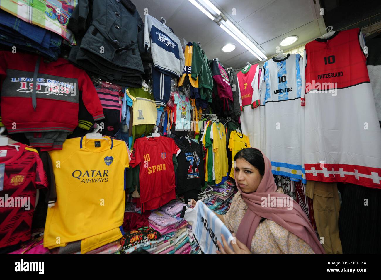 Football shirts and thobes for sale at a store in the Souq, Doha, Qatar ...