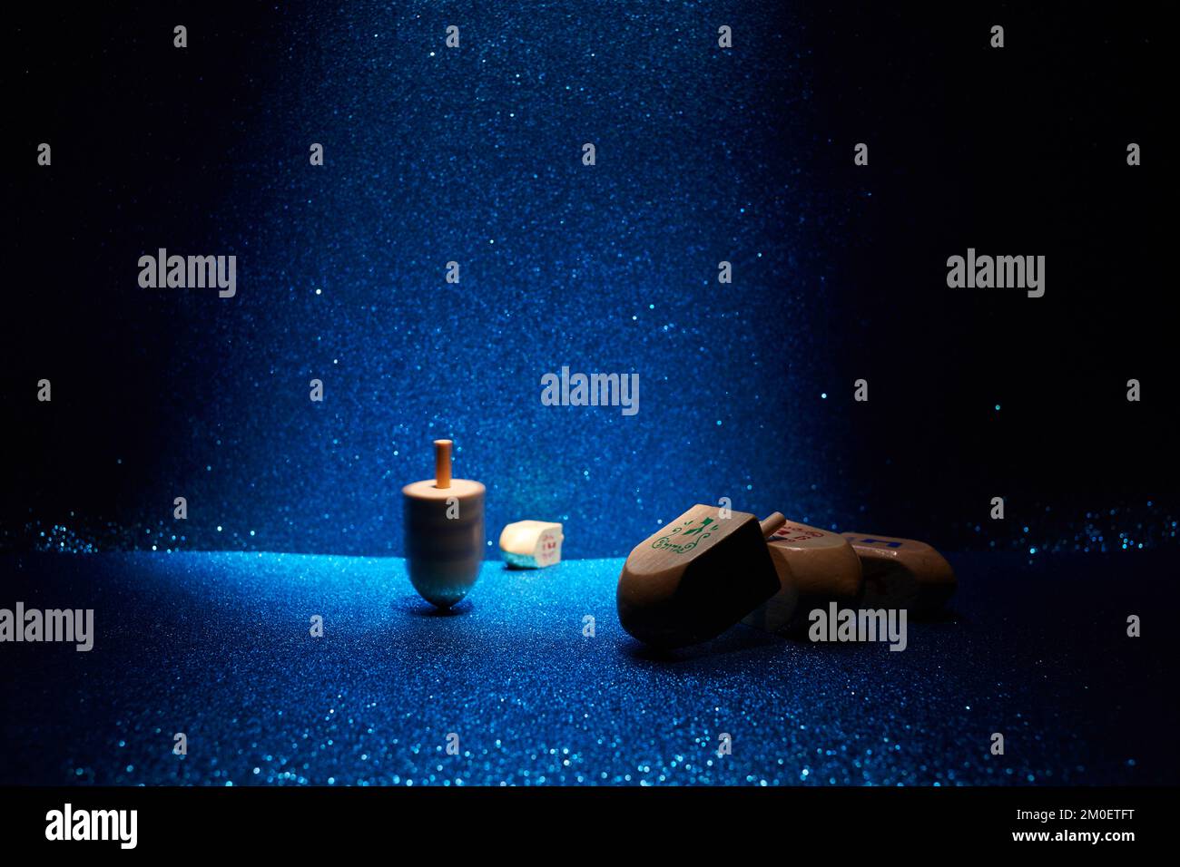 Hanukkah traditional dreidel with letters Gimel and Nun on shining blue ...