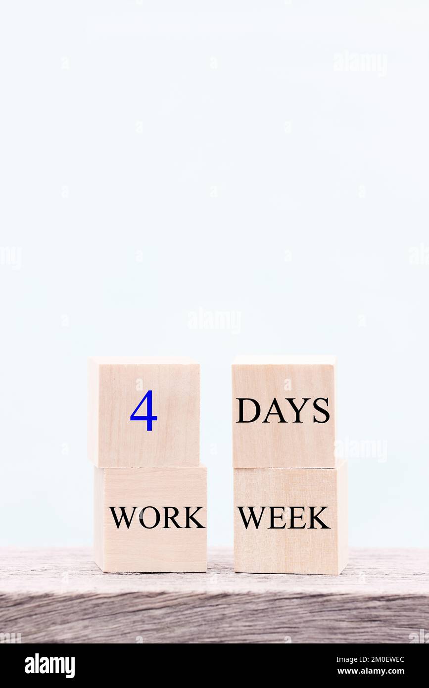 4 day working week words on wooden cube on blue background. reducing ...