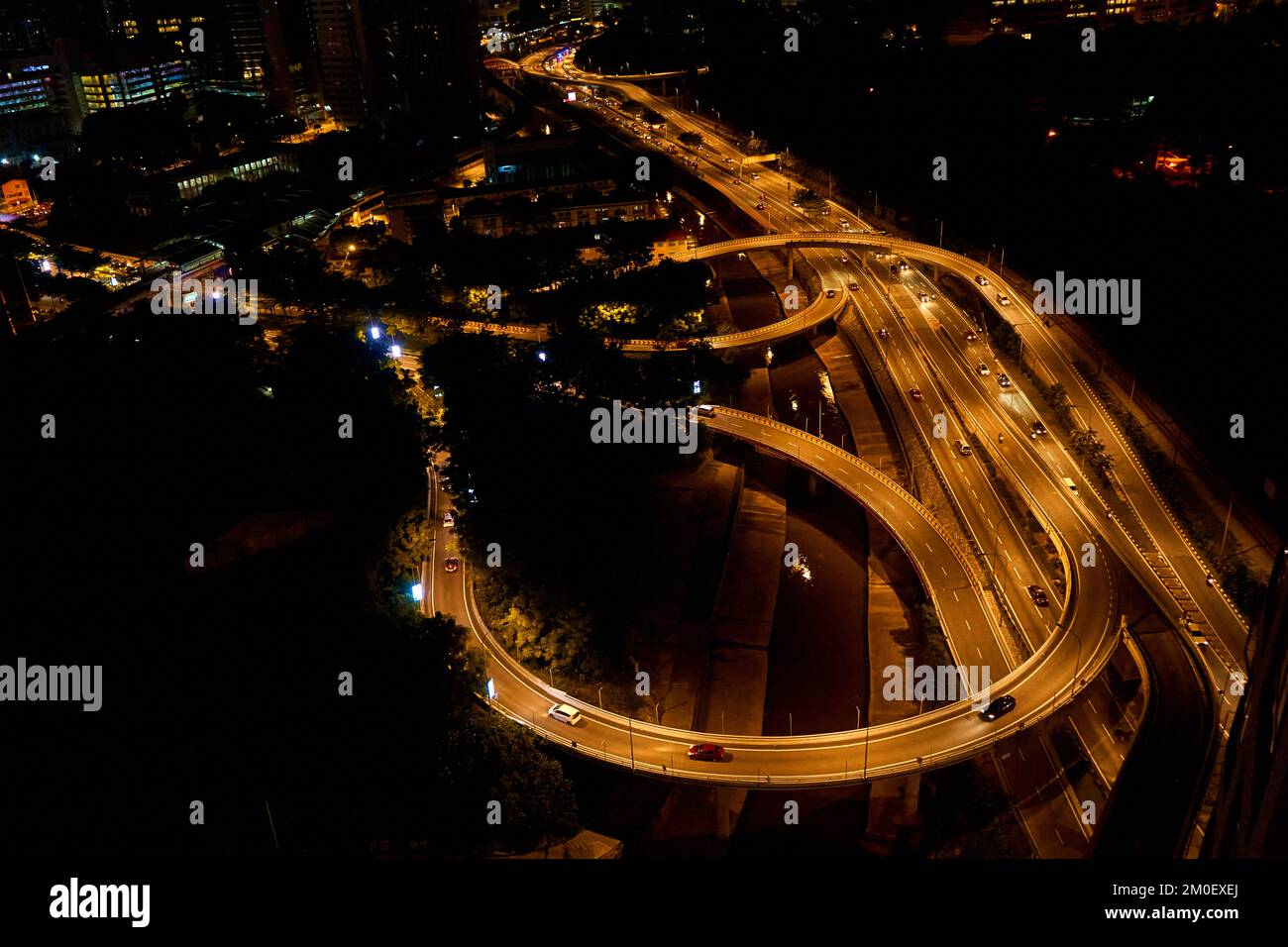 Night photo of a glowing multi-level road junction with heavy traffic ...
