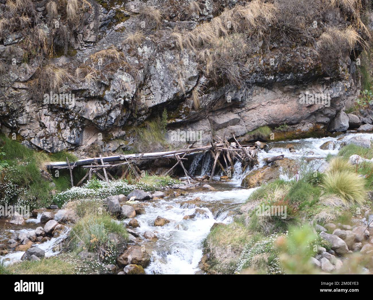 Water is diverted from a mountain stream into an irrigation channel by ...