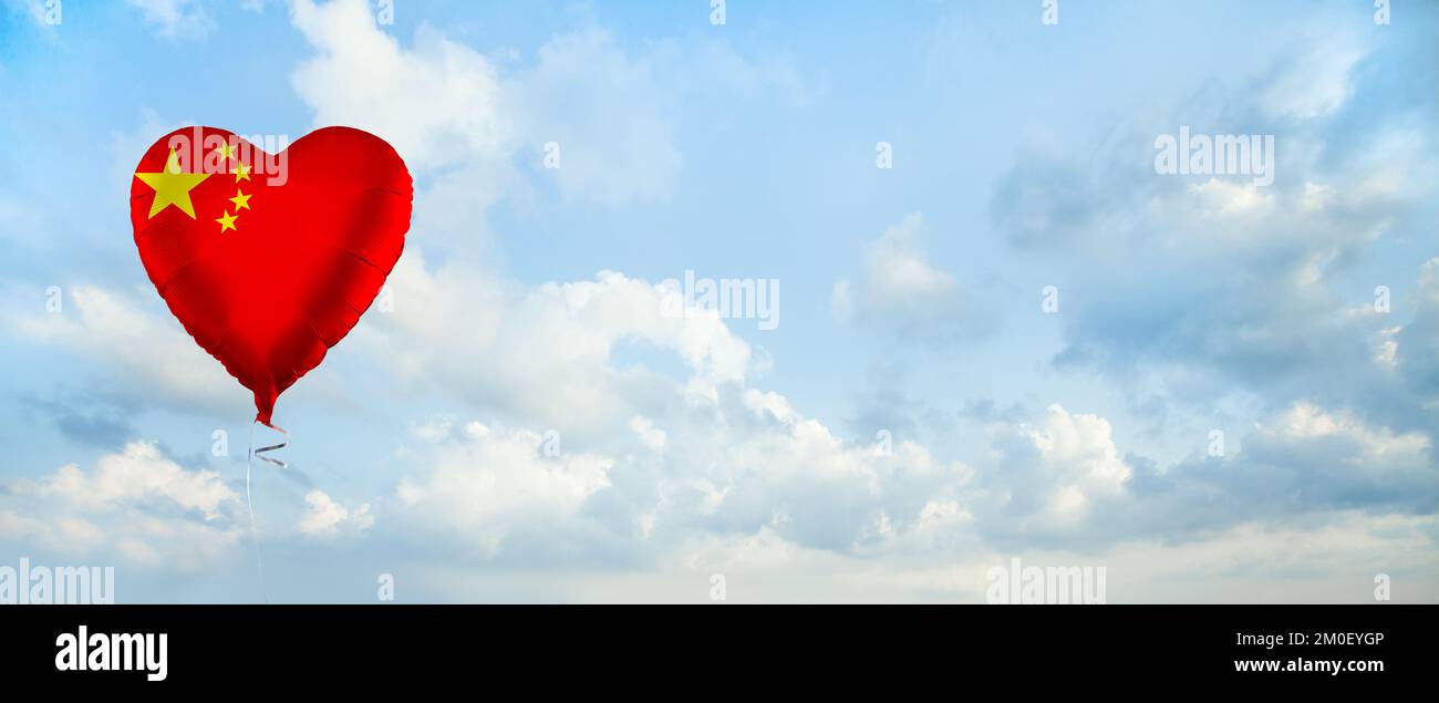 Flag of China on heart-shaped balloon against sky clouds background ...