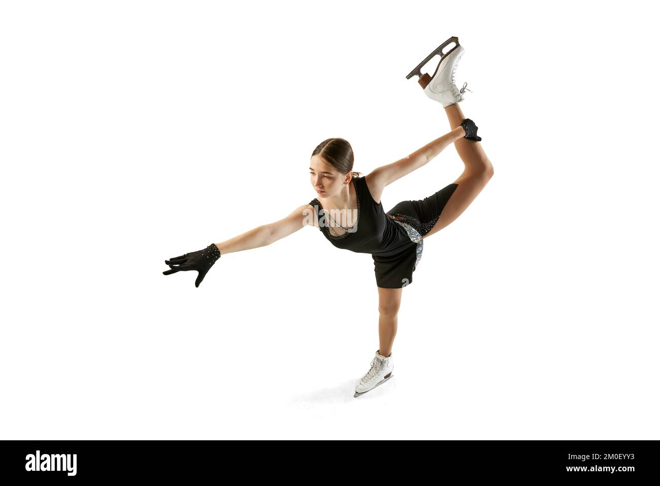 Studio shot of beautiful female figure skater in black festive stage ...